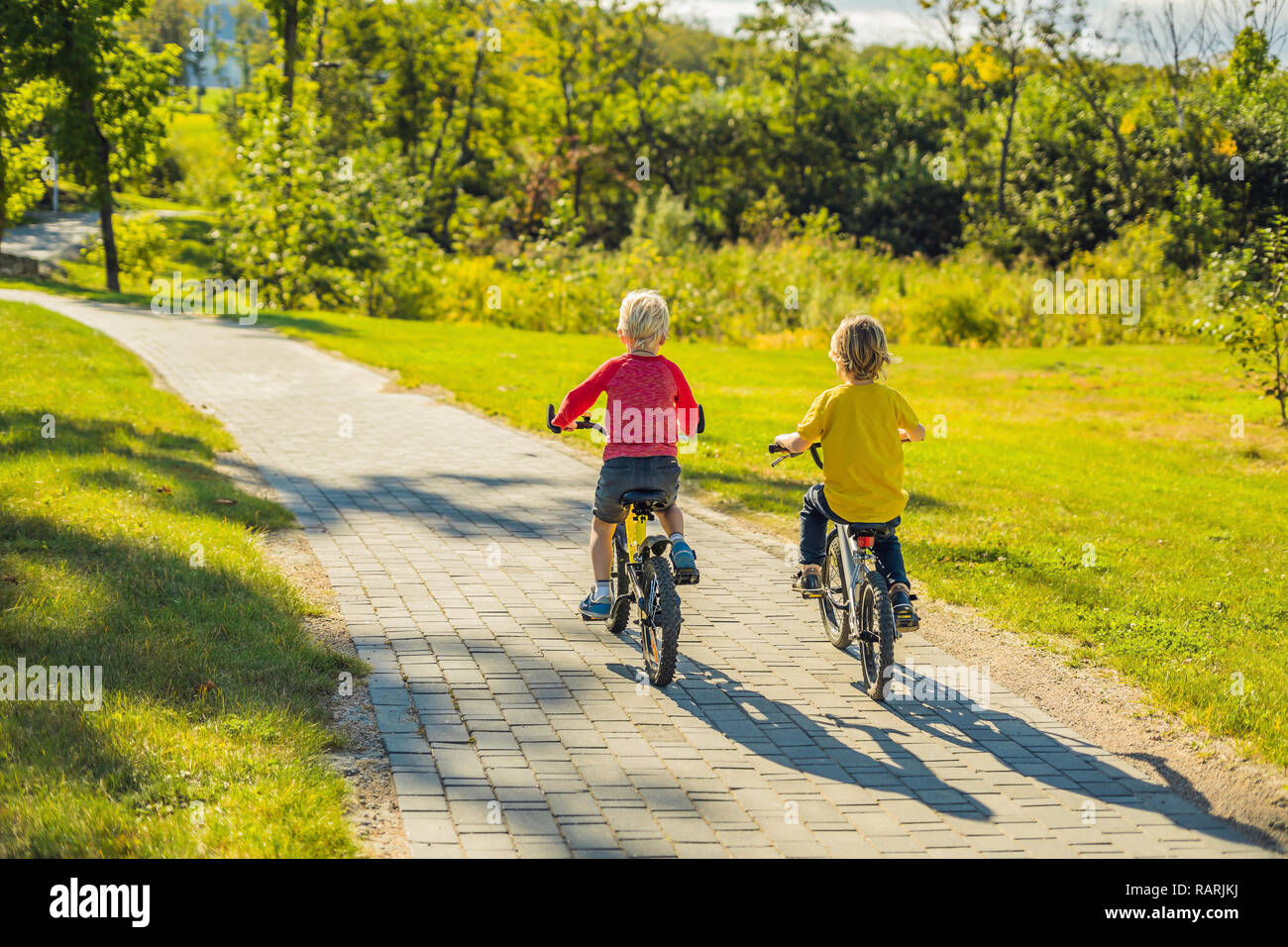 Two happy boys cycling in the park Stock Photo - Alamy