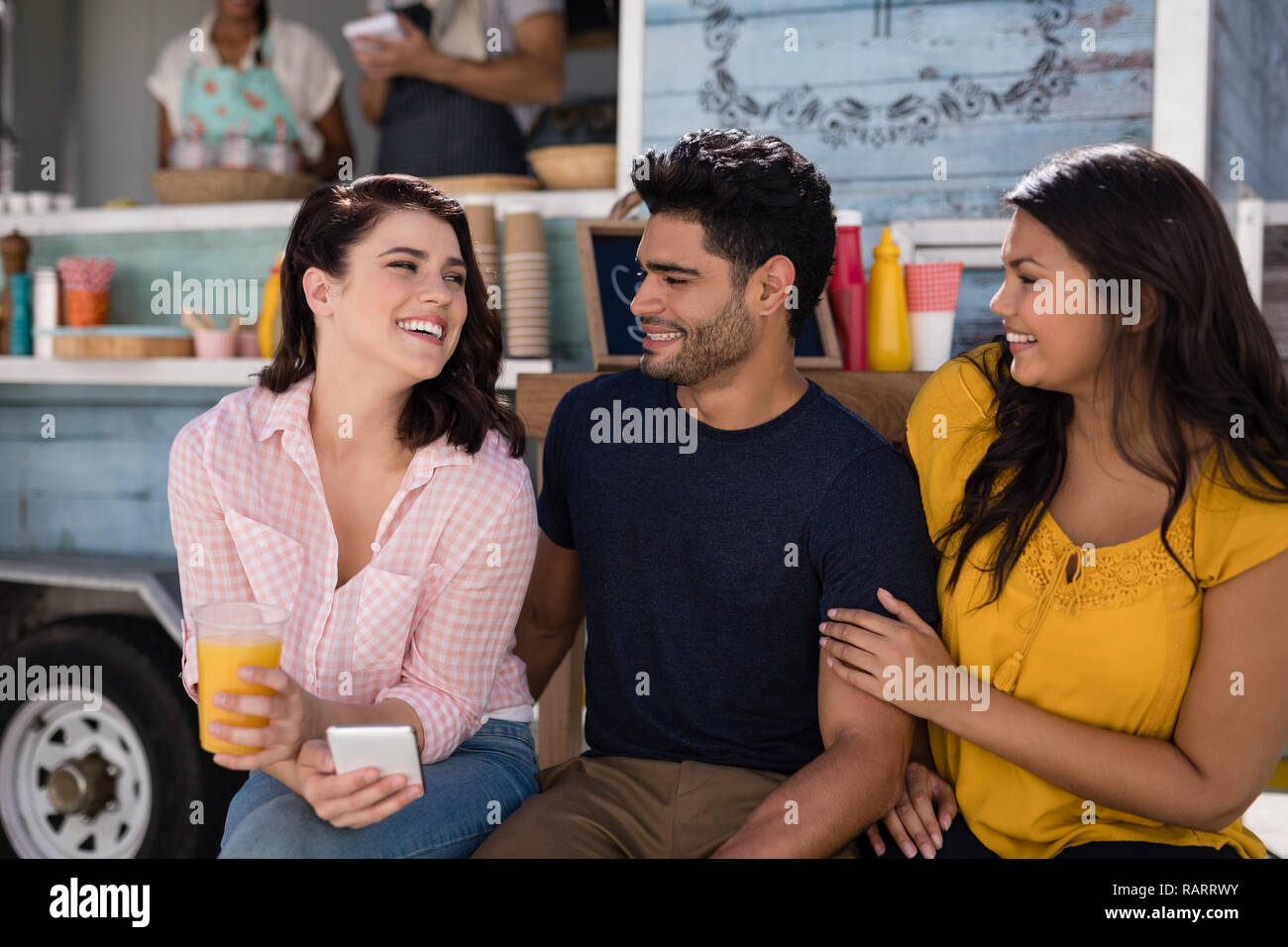 Smiling friends interacting with each other Stock Photo - Alamy