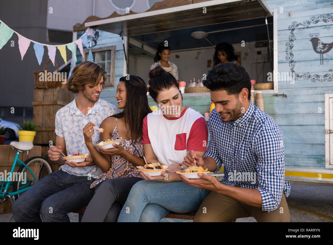 Friends interacting while having snacks Stock Photo - Alamy