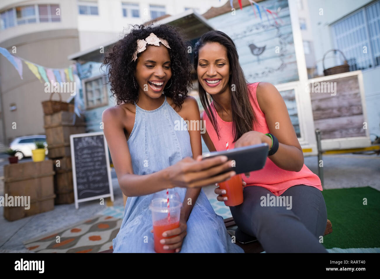 Happy friends using mobile phone Stock Photo - Alamy
