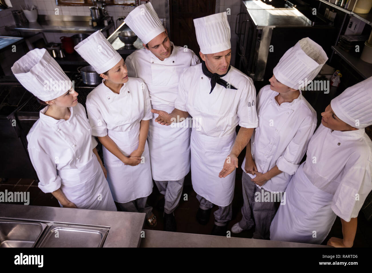 Group of chefs interacting wiht each other in kitchen Stock Photo - Alamy