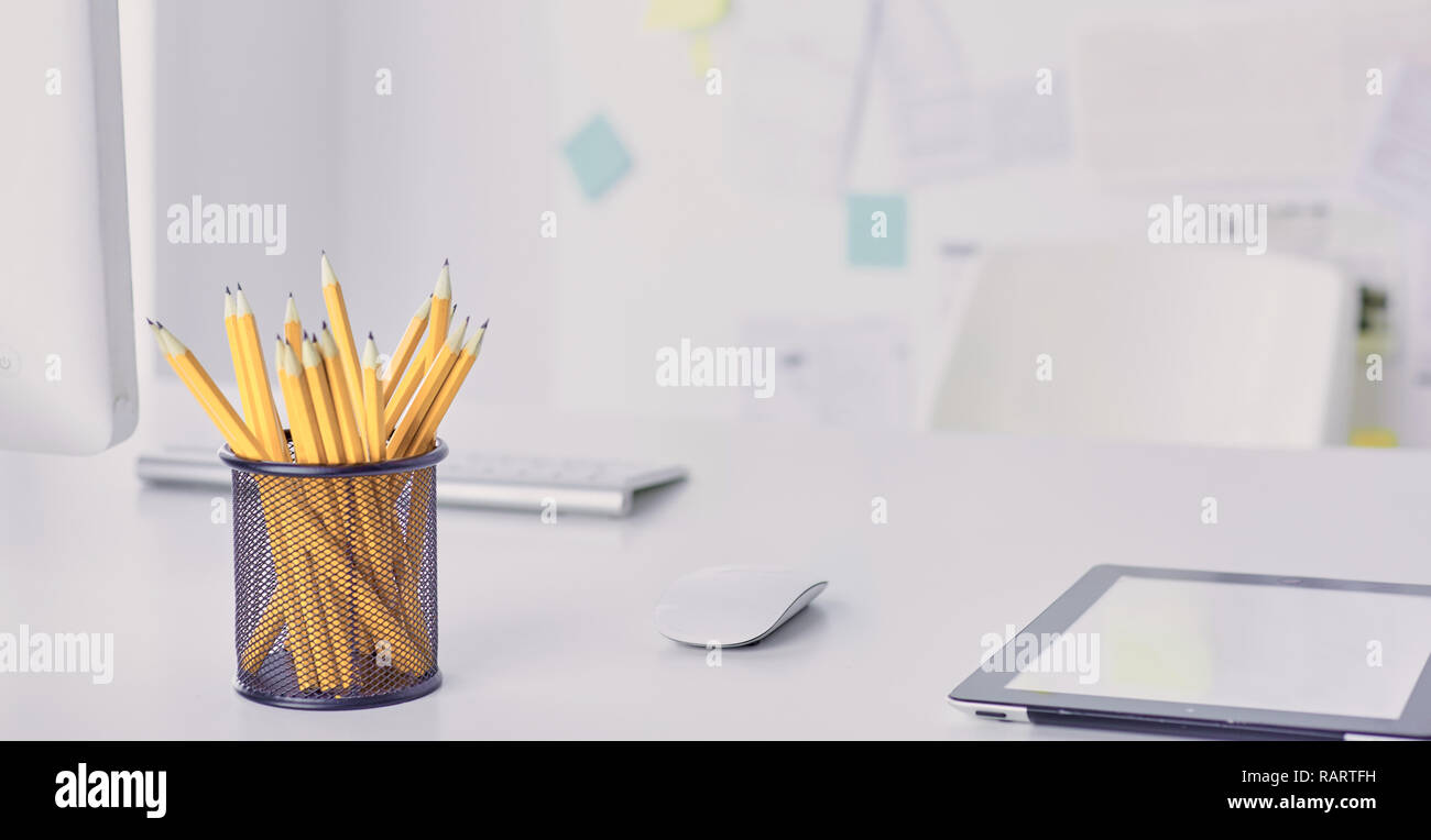 Graphite pencils in a metal grid-container on the office table. Concept ...