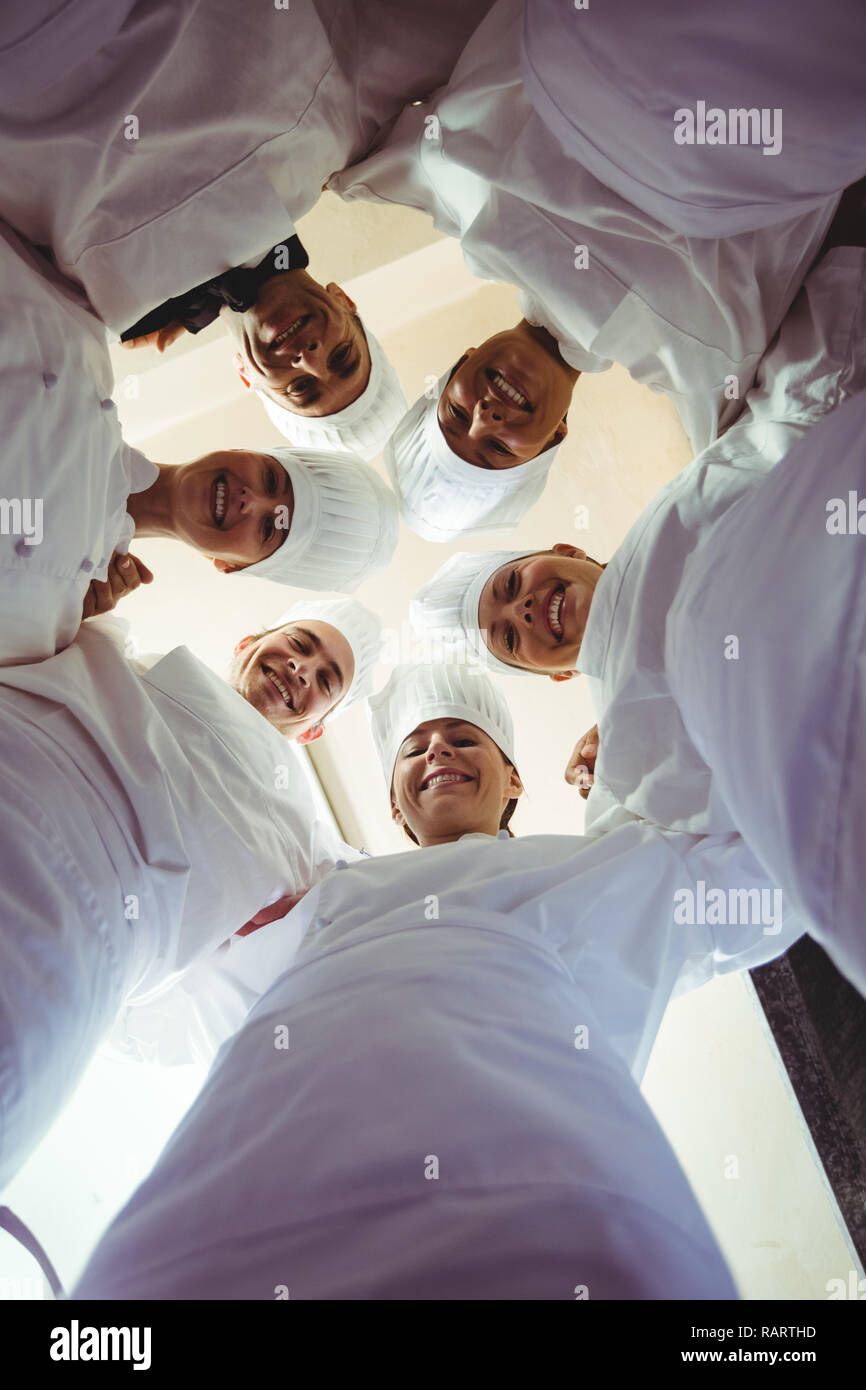 Group of chefs formig huddles in kitchen Stock Photo - Alamy