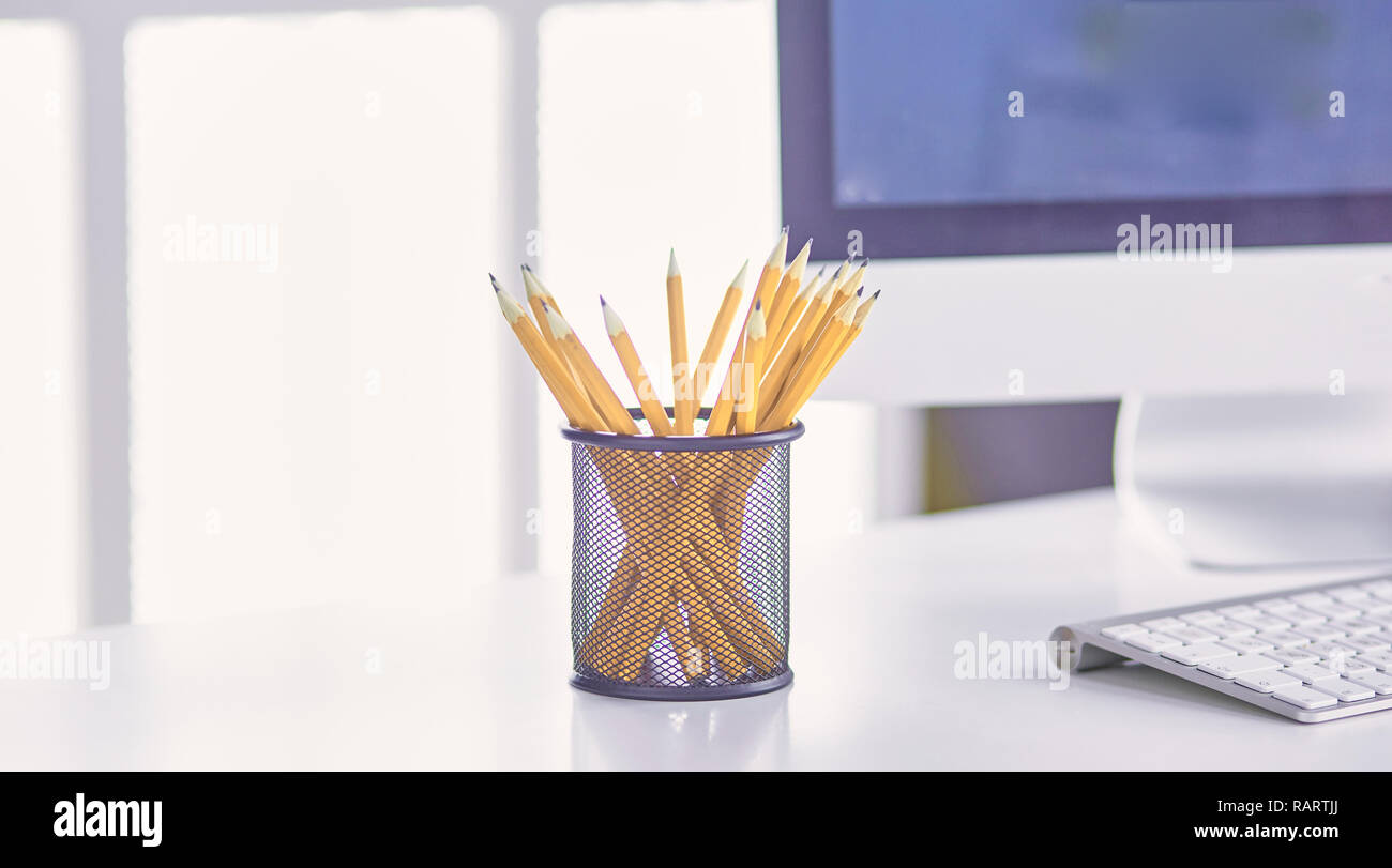 Graphite pencils in a metal grid-container on the office table. Concept ...