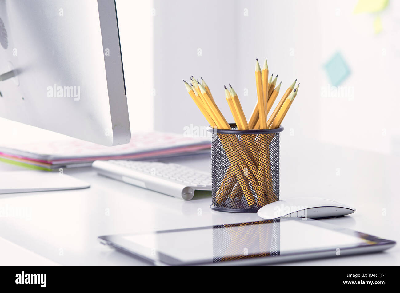Graphite pencils in a metal grid-container on the office table. Concept ...