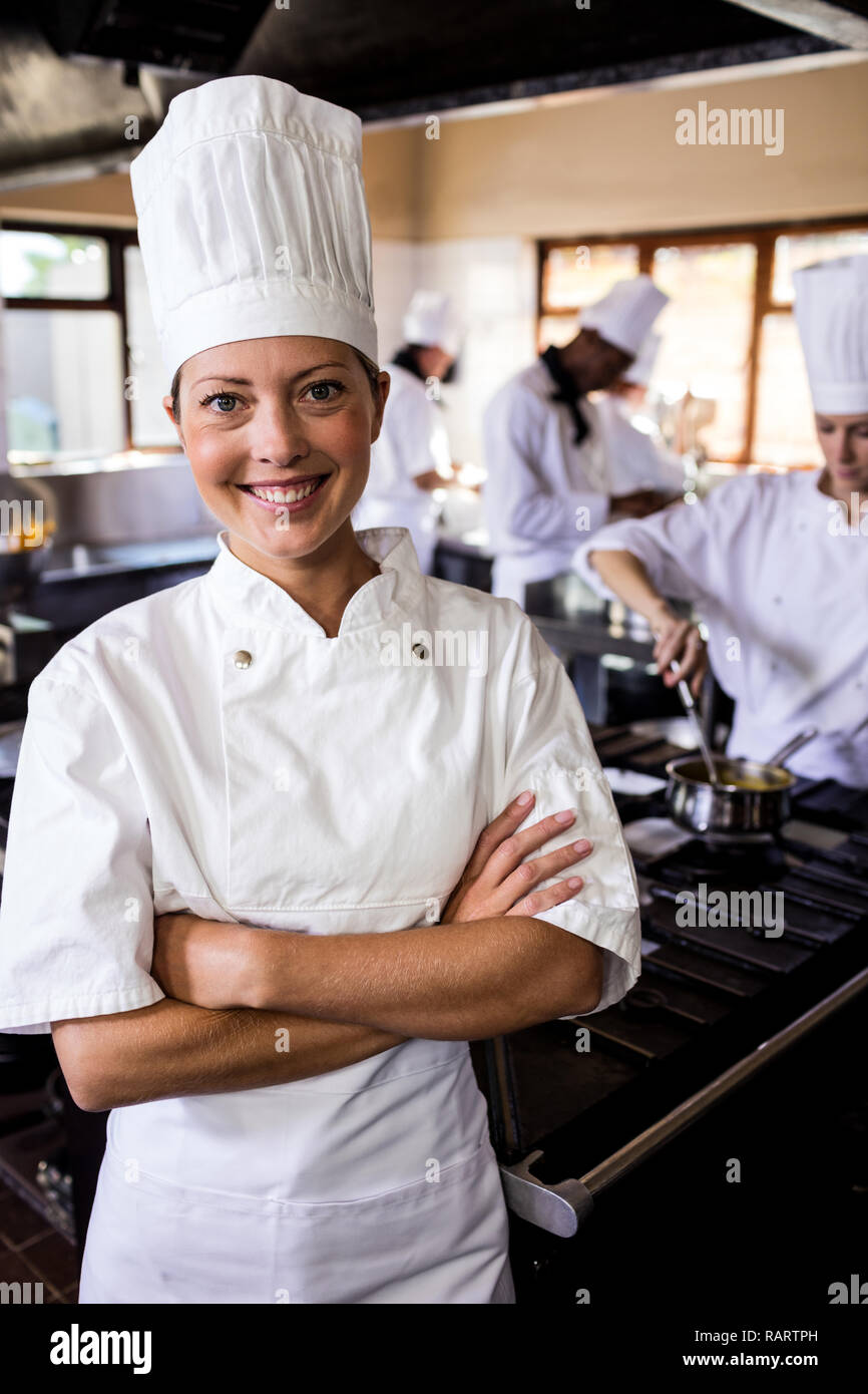 Female chef standing with arms crossed in kitchen Stock Photo - Alamy
