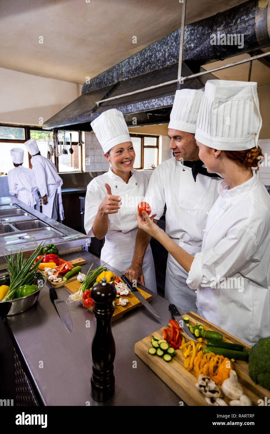 Group of chefs interacting with each other in kitchen Stock Photo - Alamy