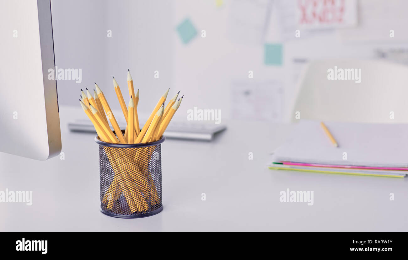 Graphite pencils in a metal grid-container on the office table. Concept ...