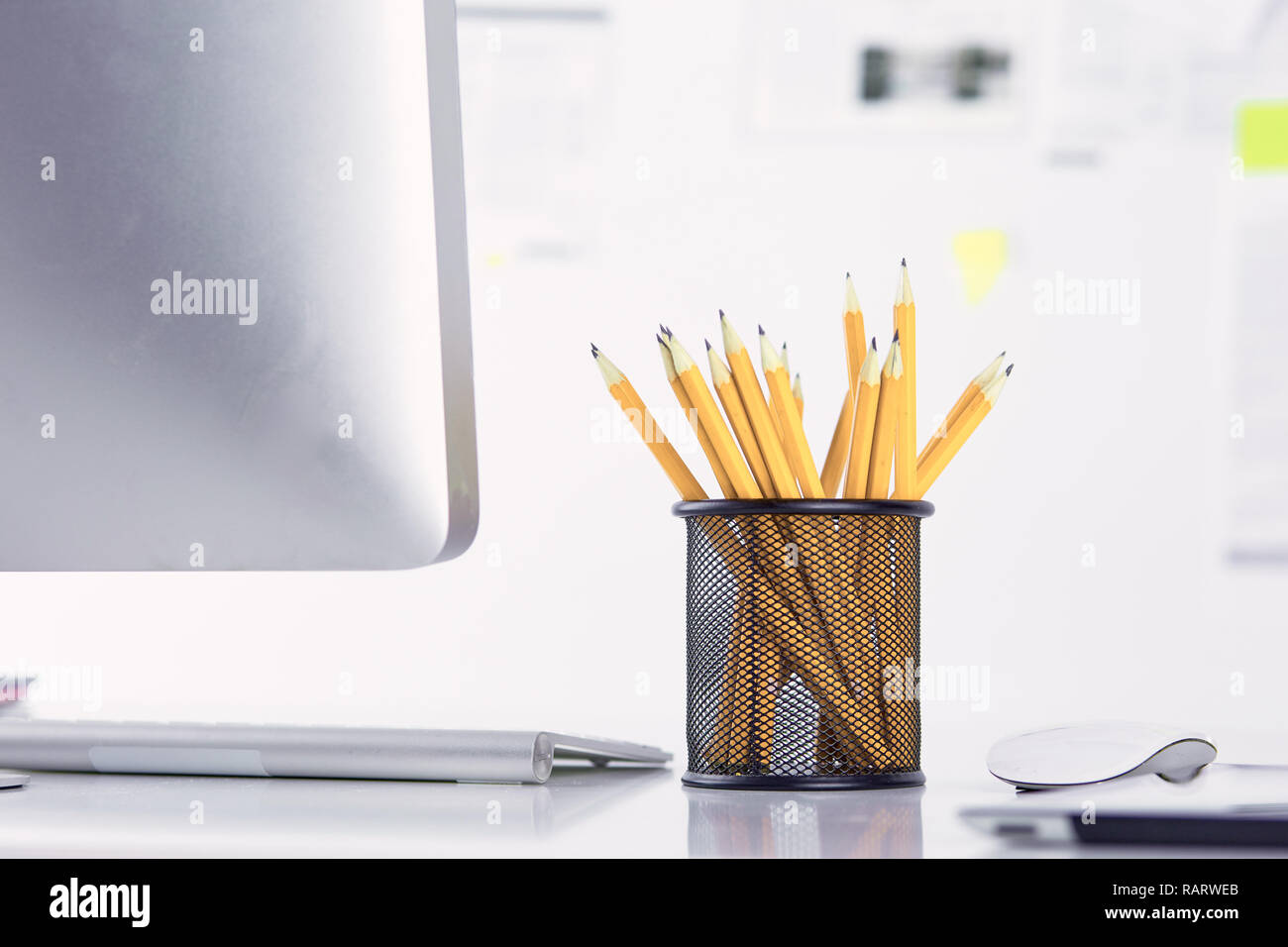 Graphite pencils in a metal grid-container on the office table. Concept ...