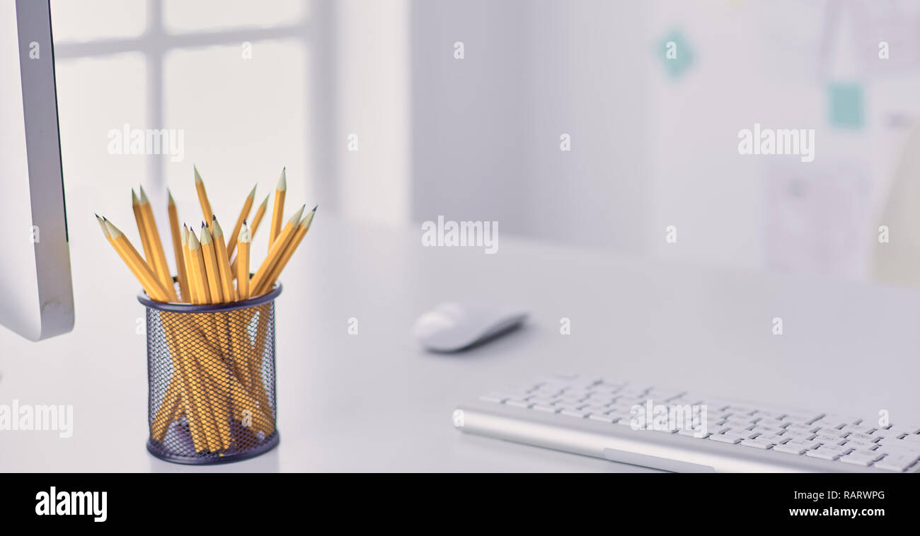 Graphite pencils in a metal grid-container on the office table. Concept ...