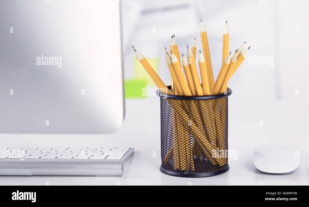 Graphite pencils in a metal grid-container on the office table. Concept ...