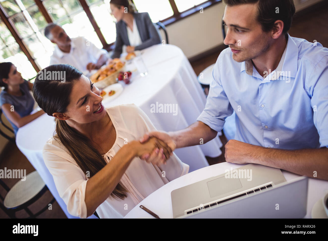 Business people shaking hands in restaurant Stock Photo - Alamy