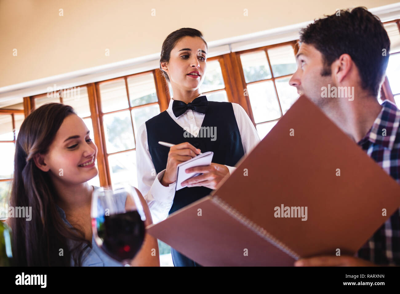 Waitress taking an order from a couple Stock Photo - Alamy