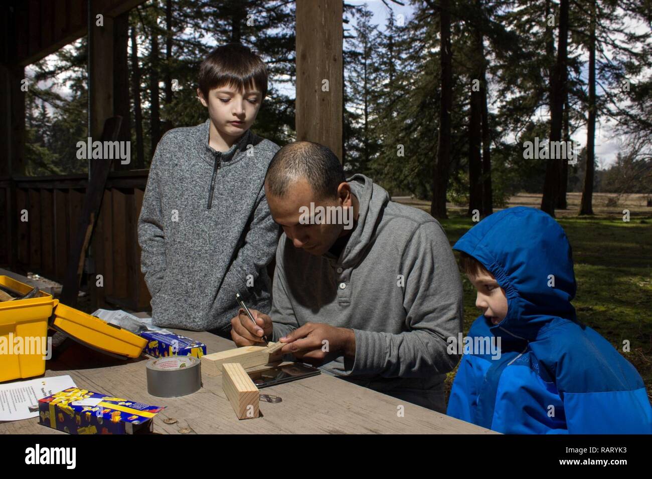 William Lugo (center), a Scouting parent, helps his son Liam Lugo (left ...