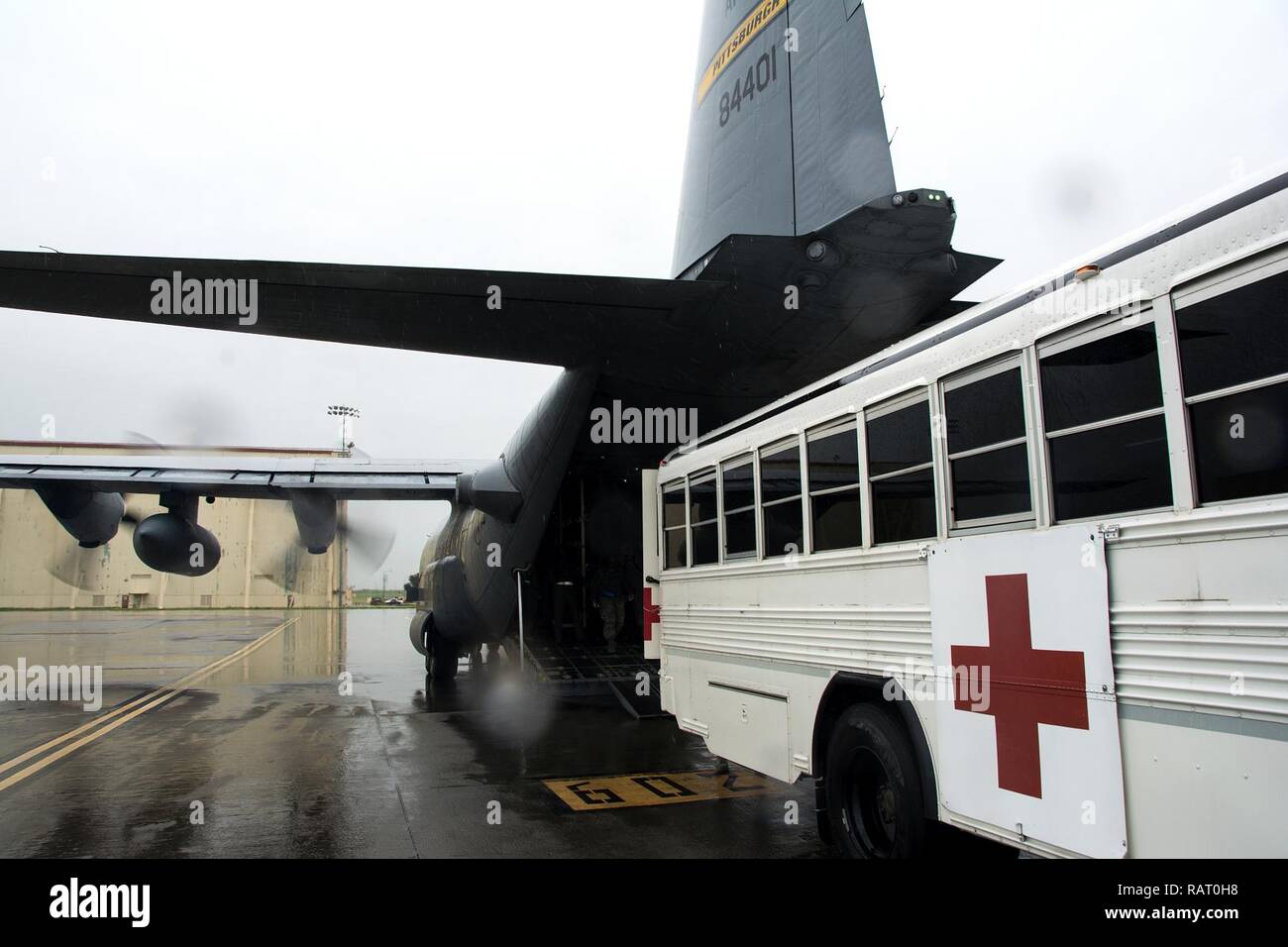 An ambulance bus from the 60th Inpatient Squadron backs up to a C-130 ...