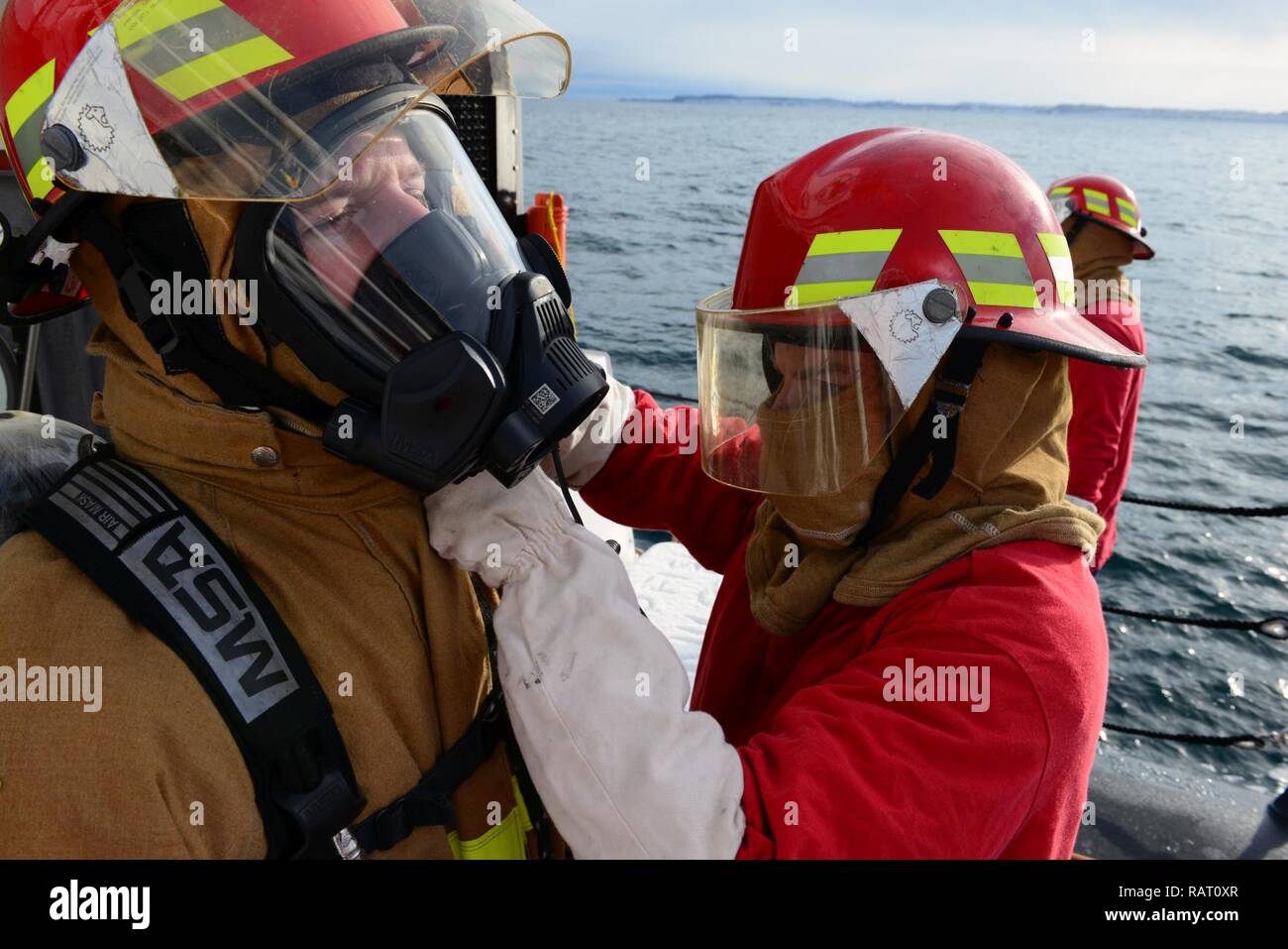 Crewmembers aboard the Coast Guard Cutter Swordfish assist each other ...