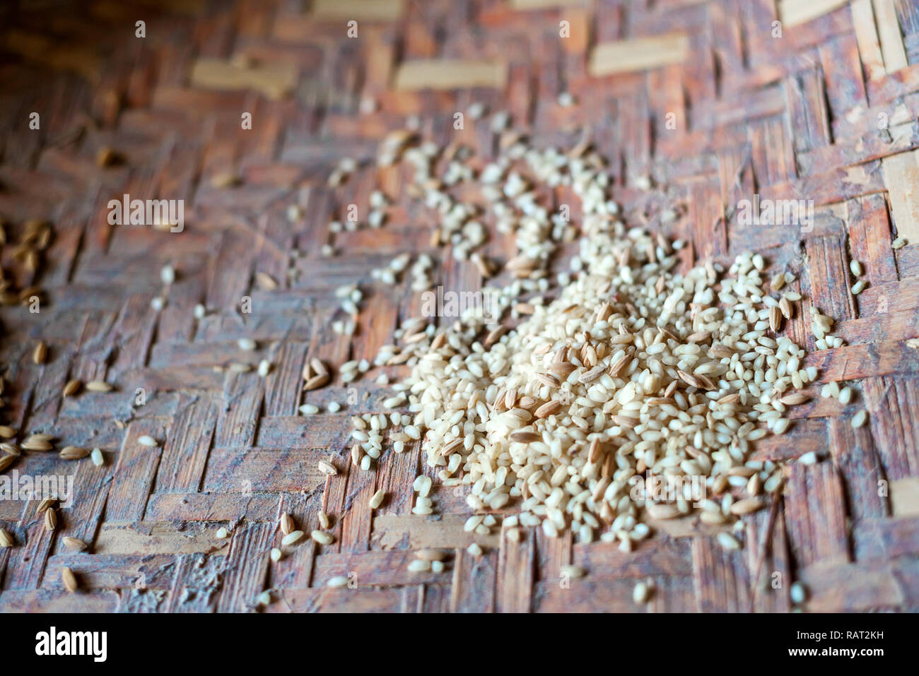 A pile of unpeeled and peeled rice in woven bowl Stock Photo - Alamy