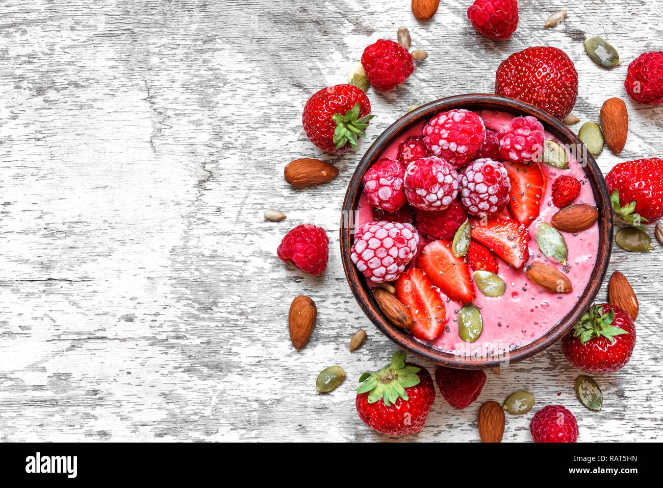 Smoothie bowl with red berries - strawberry and frozen raspberry, nuts ...