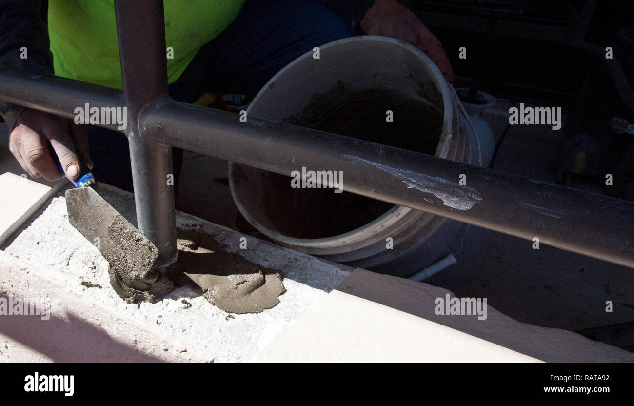 Construction Worker Pouring Concrete To Support Metal Railing Stock ...