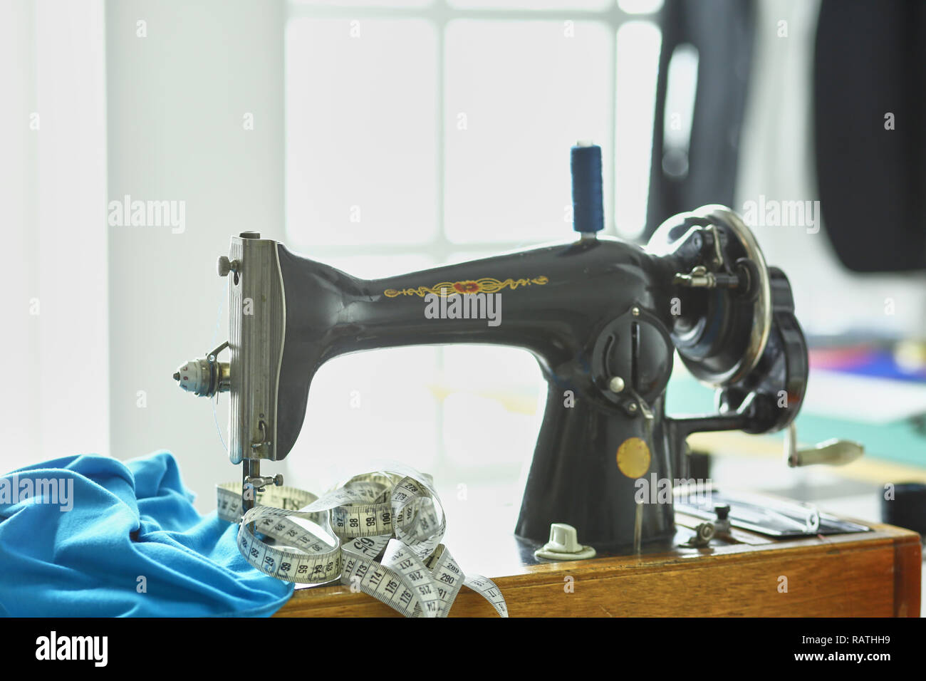 Retro sewing machine on designer clothes desktop Stock Photo - Alamy