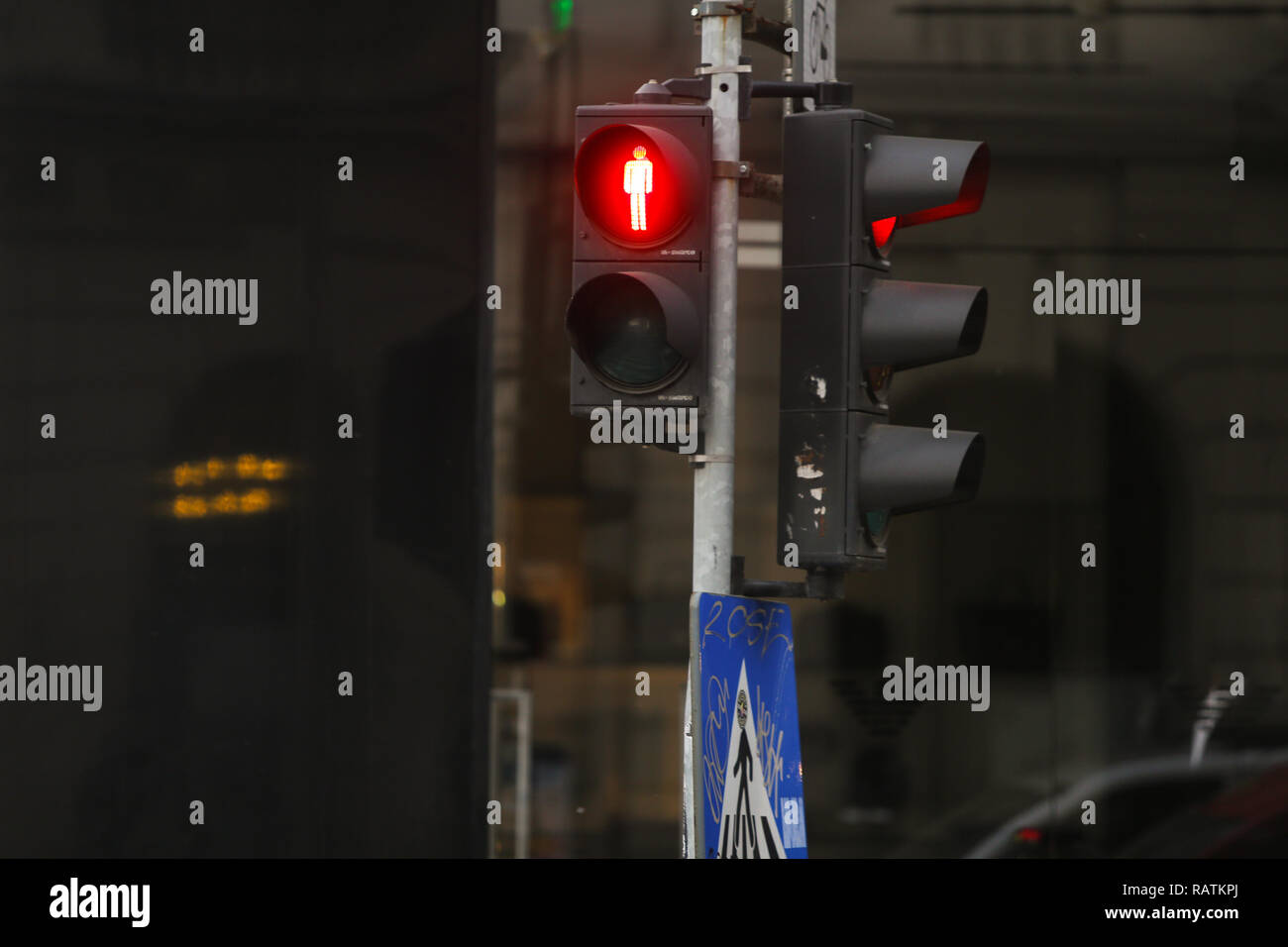 Red traffic light for pedestrians and red for cars on a city street and ...