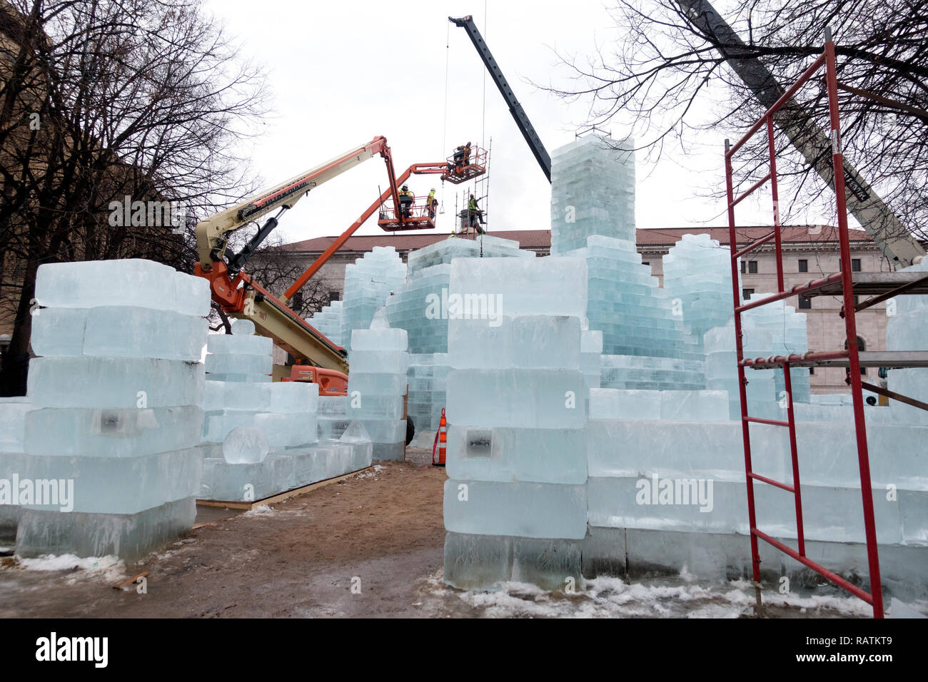 Men up in cherry picker and scaffolding building Ice castle in Rice ...
