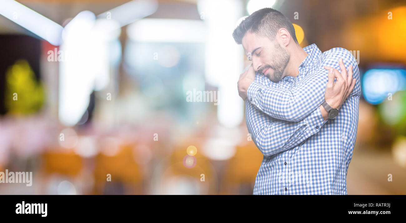Young handsome man over isolated background Hugging oneself happy and ...