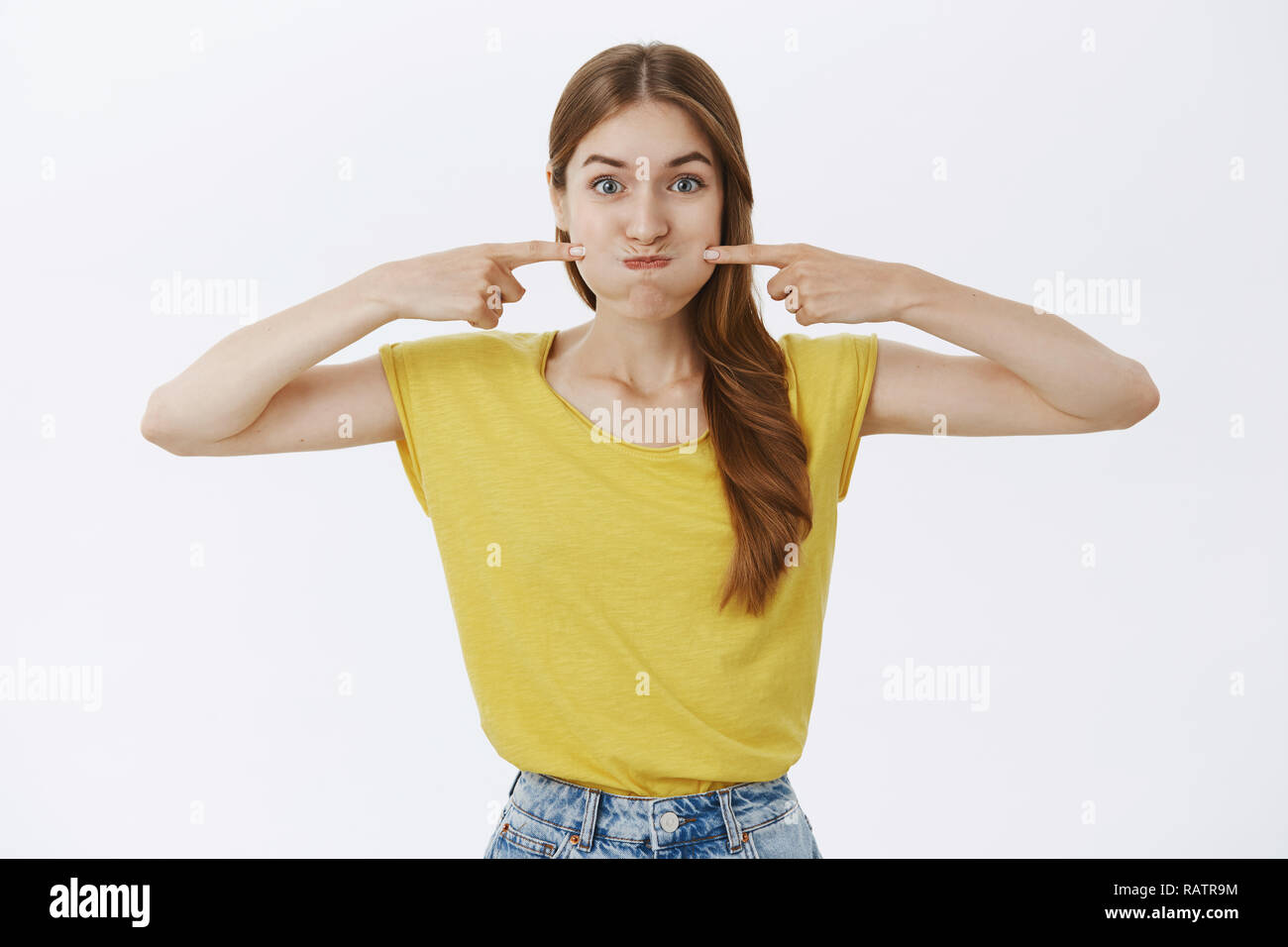 Charismatic funny and happy charming young female in yellow t-shirt ...