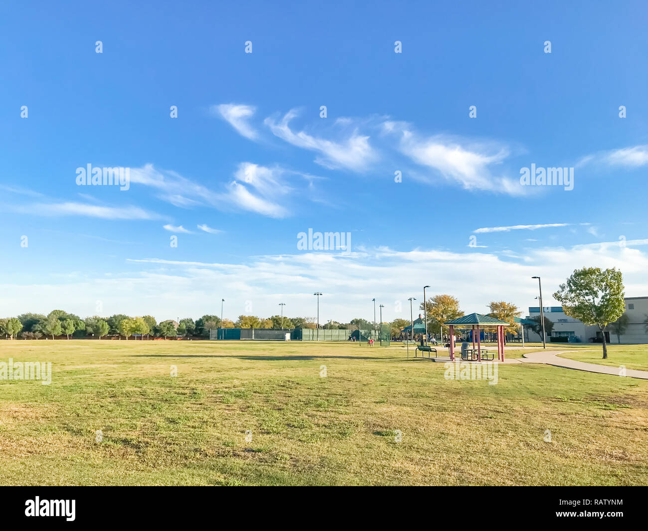 Urban park with concrete trail and green grass lawn at sunset Stock ...