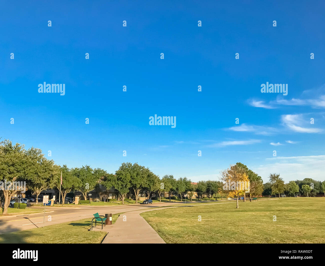 Urban park with concrete trail and green grass lawn at sunset Stock ...
