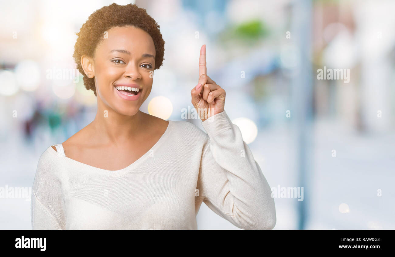 Young african american woman over isolated background pointing finger ...