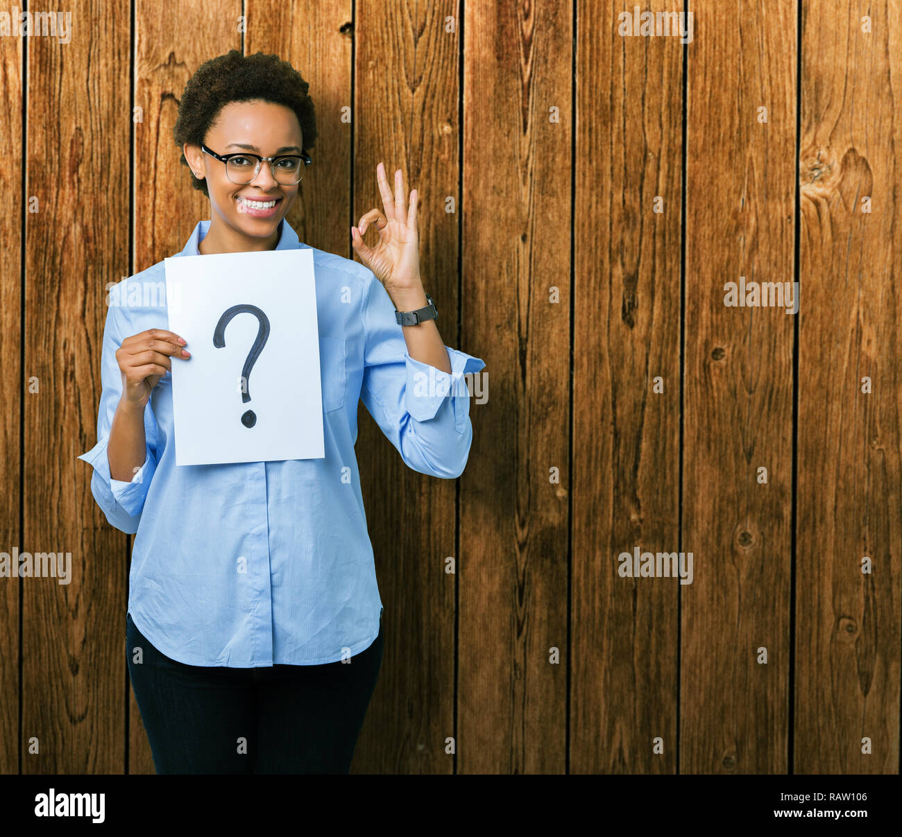 Young african american woman holding paper with question mark over ...