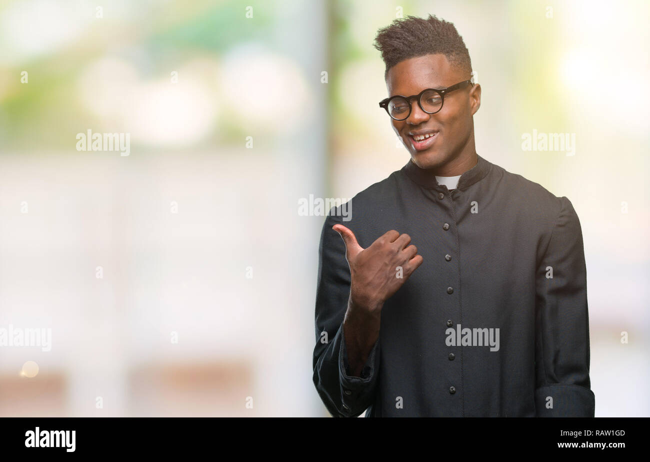 Young african american priest man over isolated background smiling with ...