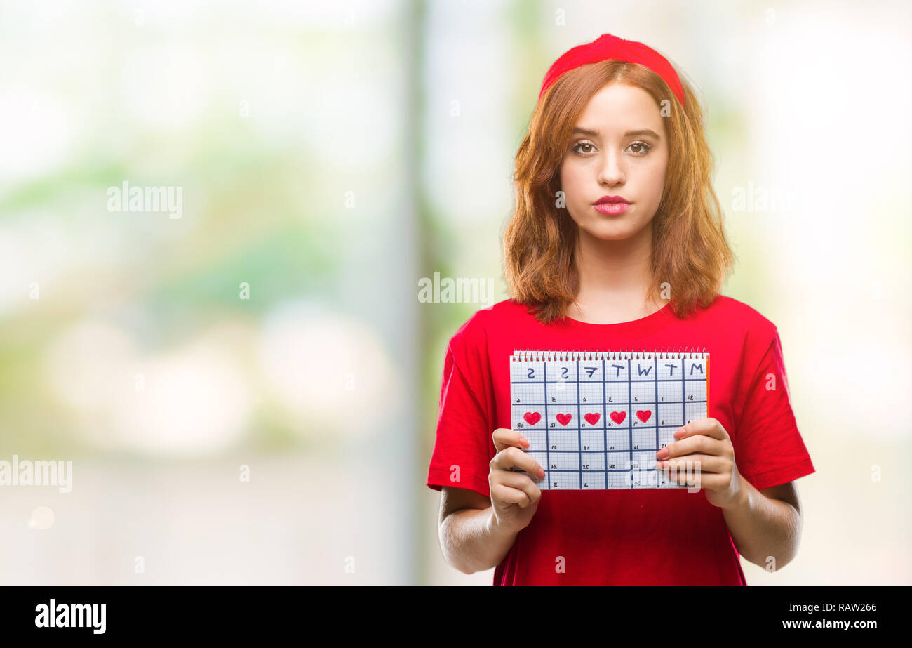 Young beautiful woman over isolated background holding menstruation ...