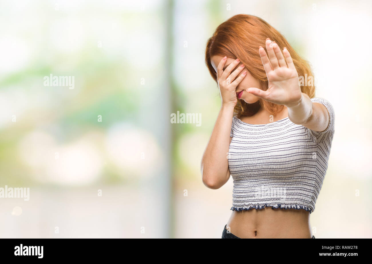 Young beautiful woman over isolated background covering eyes with hands ...