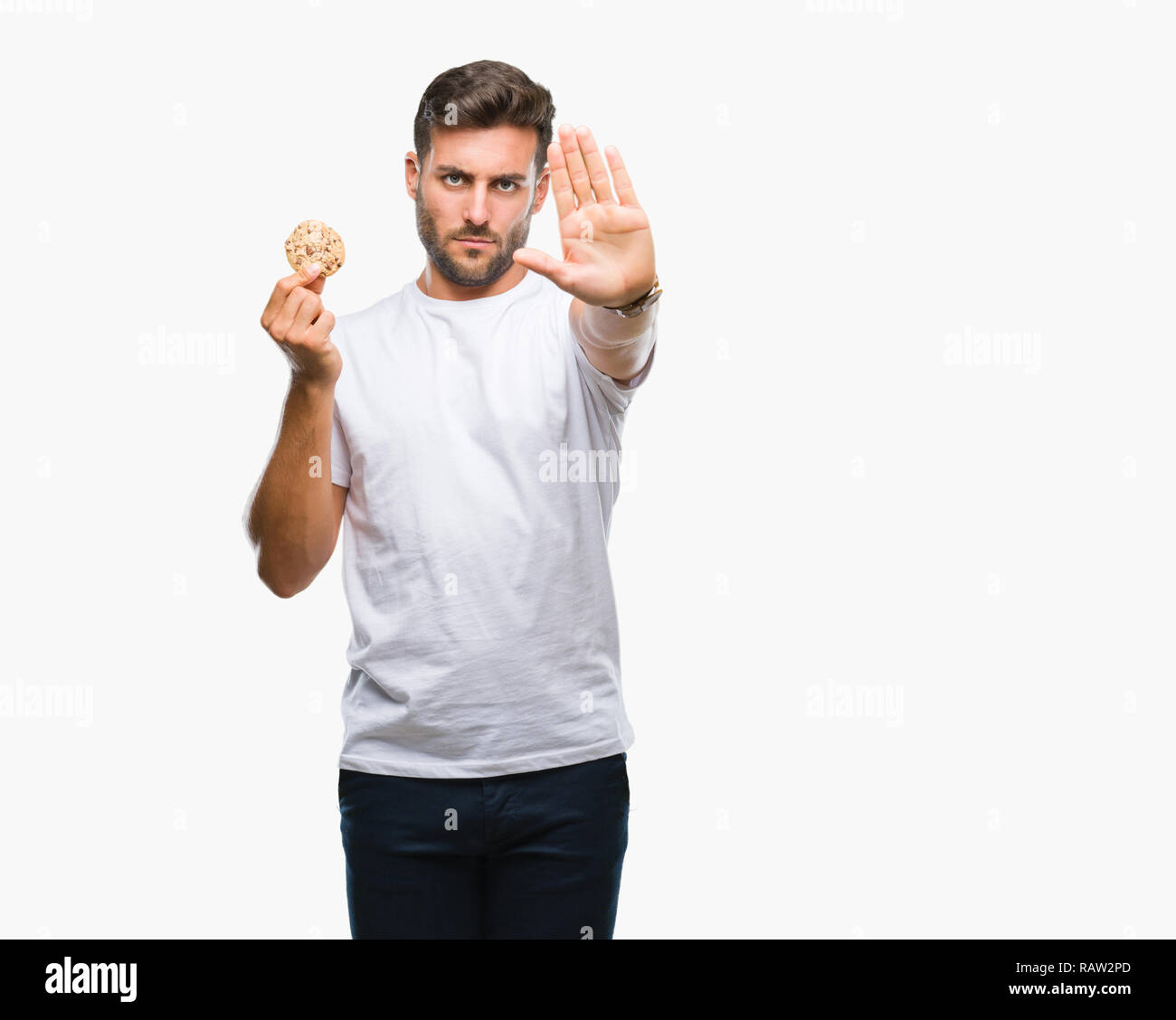 Young handsome man eating chocolate chips cookie over isolated ...