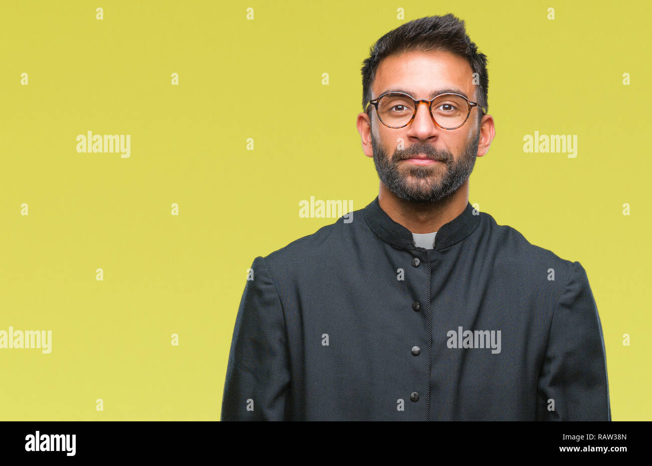 Adult hispanic catholic priest man over isolated background with ...