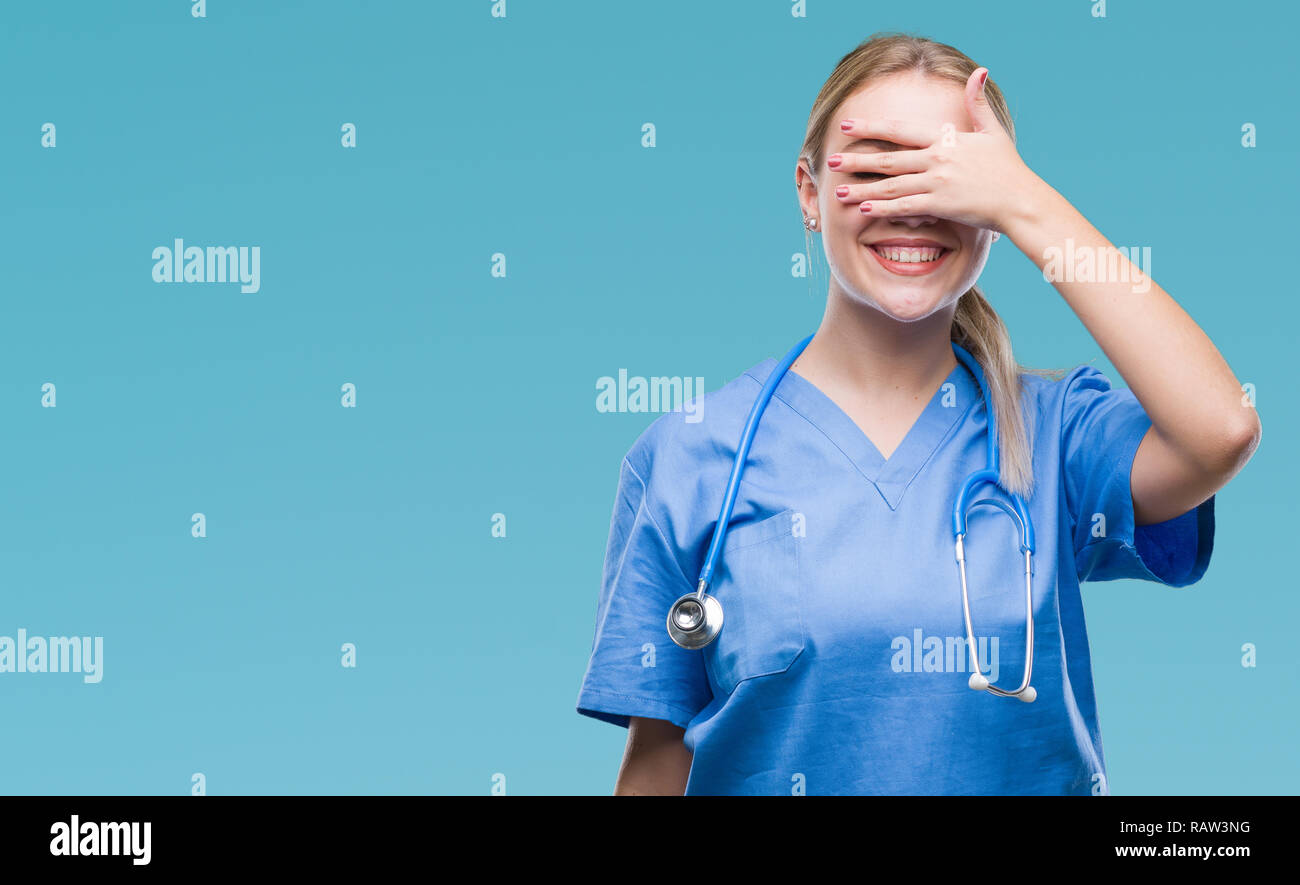 Young blonde surgeon doctor woman over isolated background smiling and ...