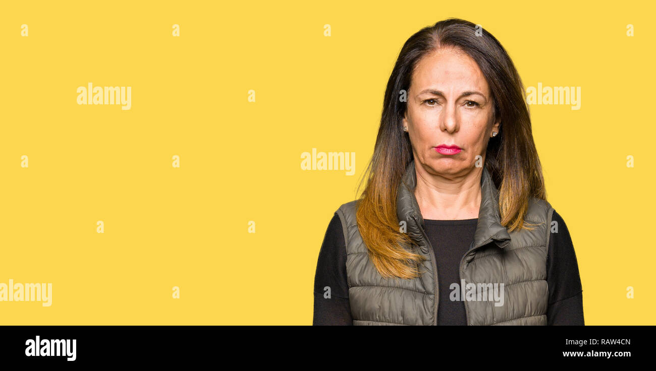 Beautiful middle age woman wearing winter vest depressed and worry for ...