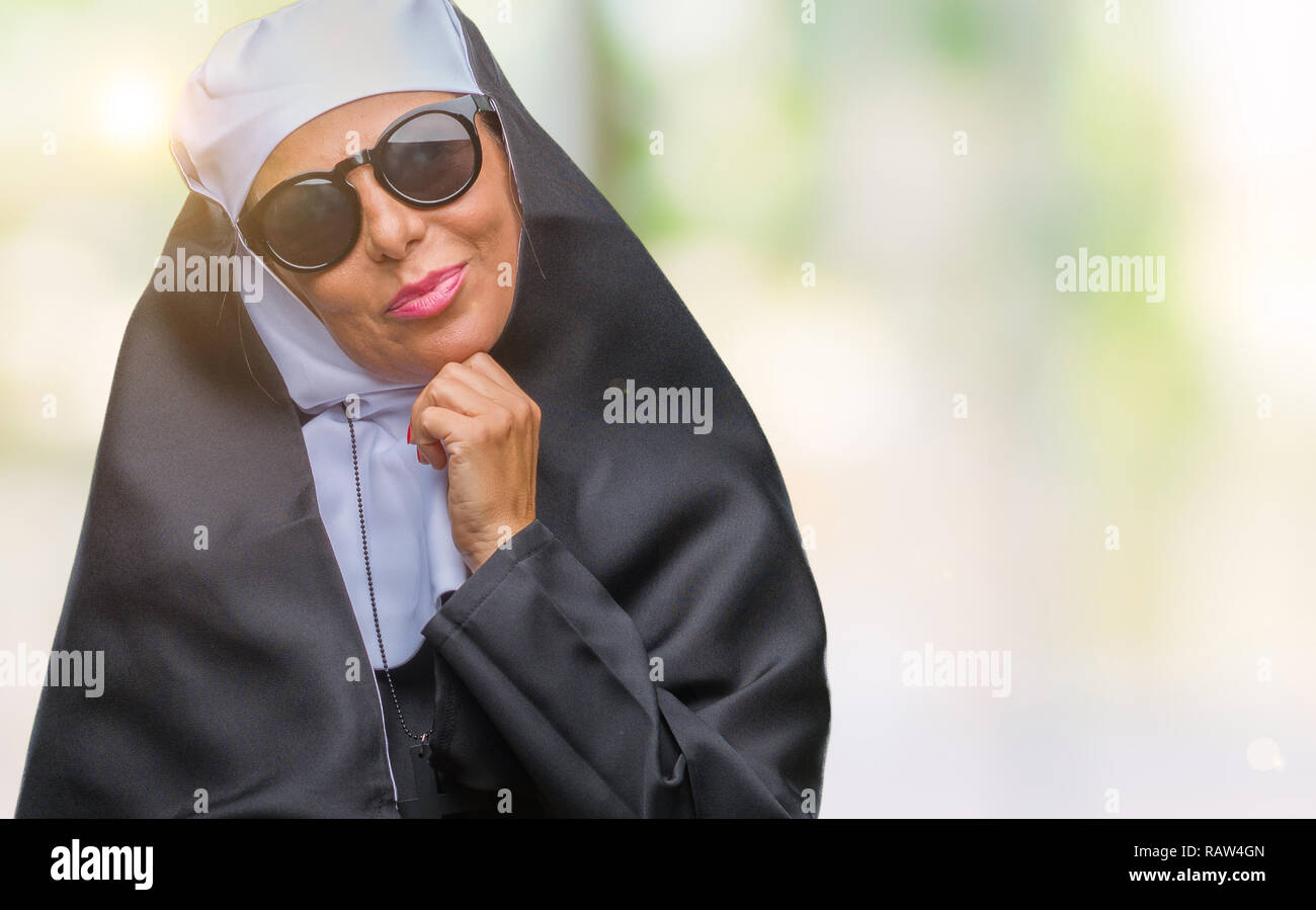Middle age senior catholic nun woman wearing sunglasses over isolated ...