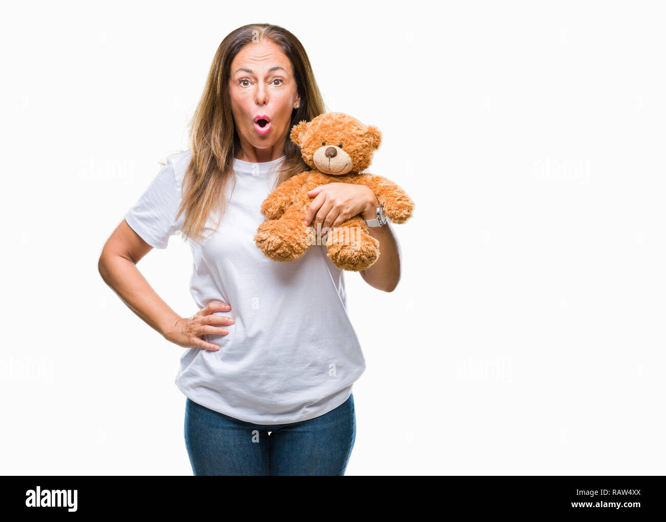 Middle age hispanic woman holding cute teddy bear plush over isolated ...