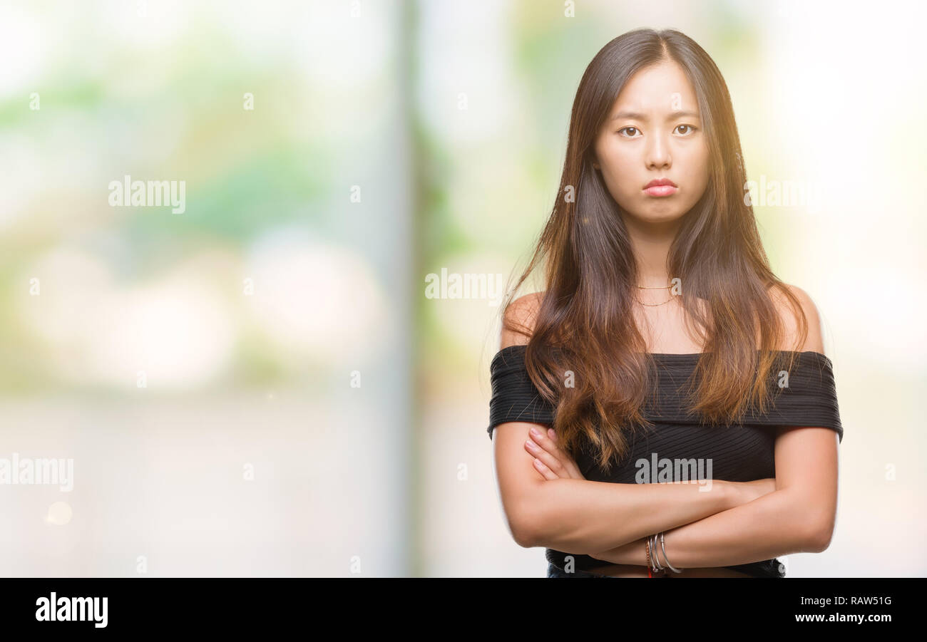 Young asian woman over isolated background skeptic and nervous ...