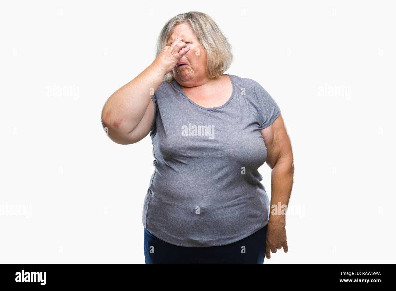 Senior plus size caucasian woman over isolated background smelling ...
