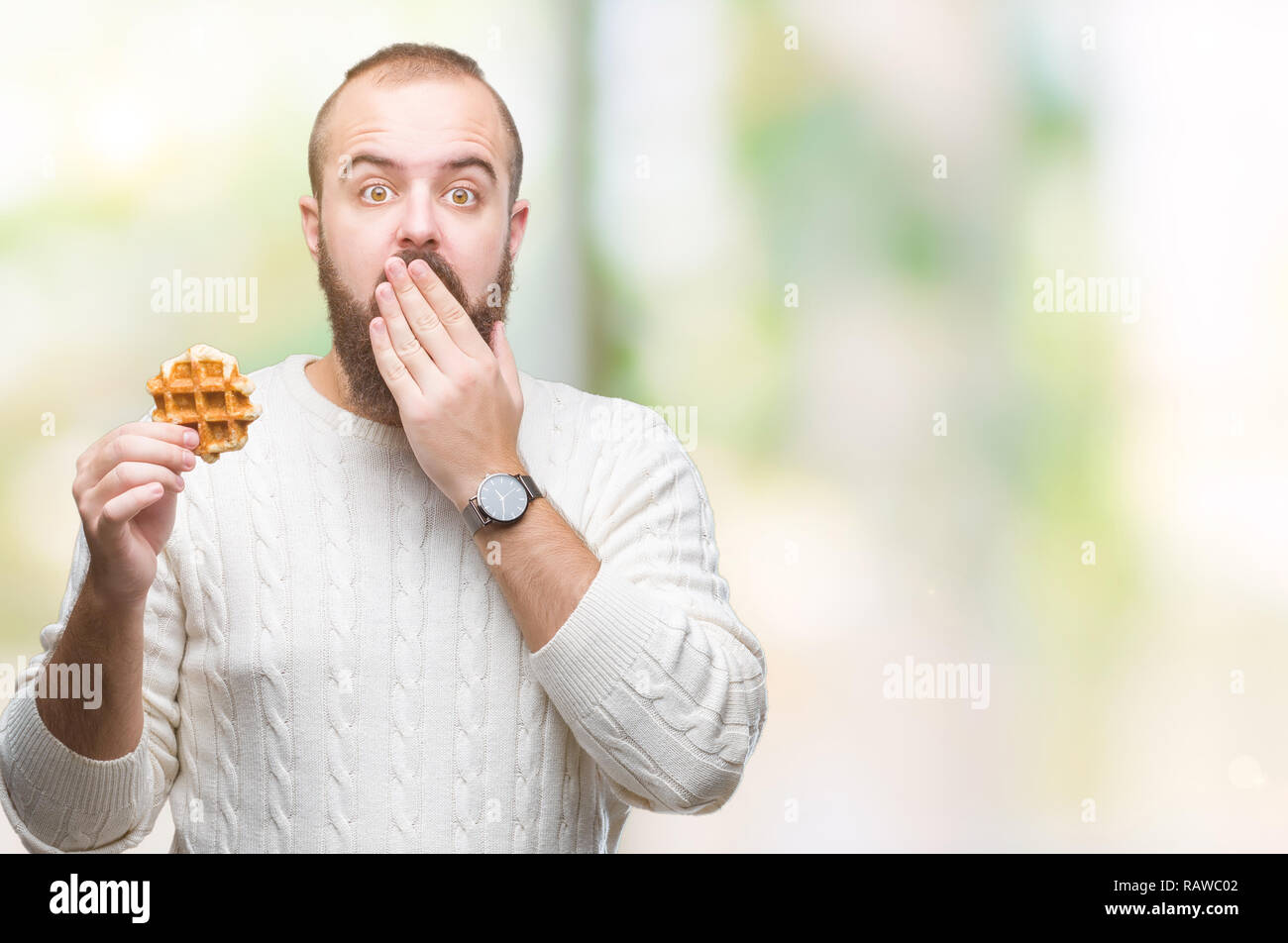 Young caucasian hipster man eating sweet waffle over isolated ...