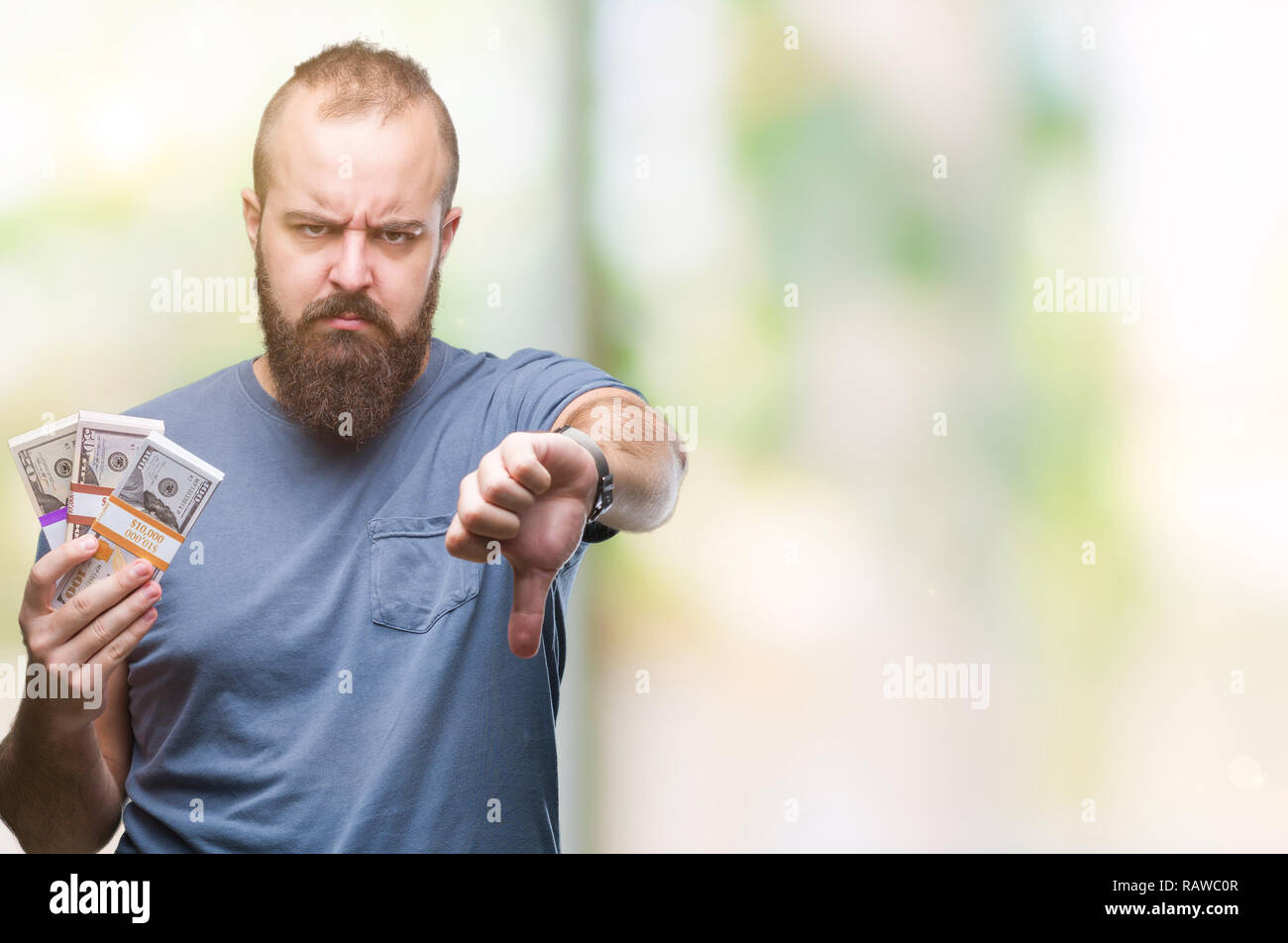Young hipster man holding bunch of money over isolated background with ...