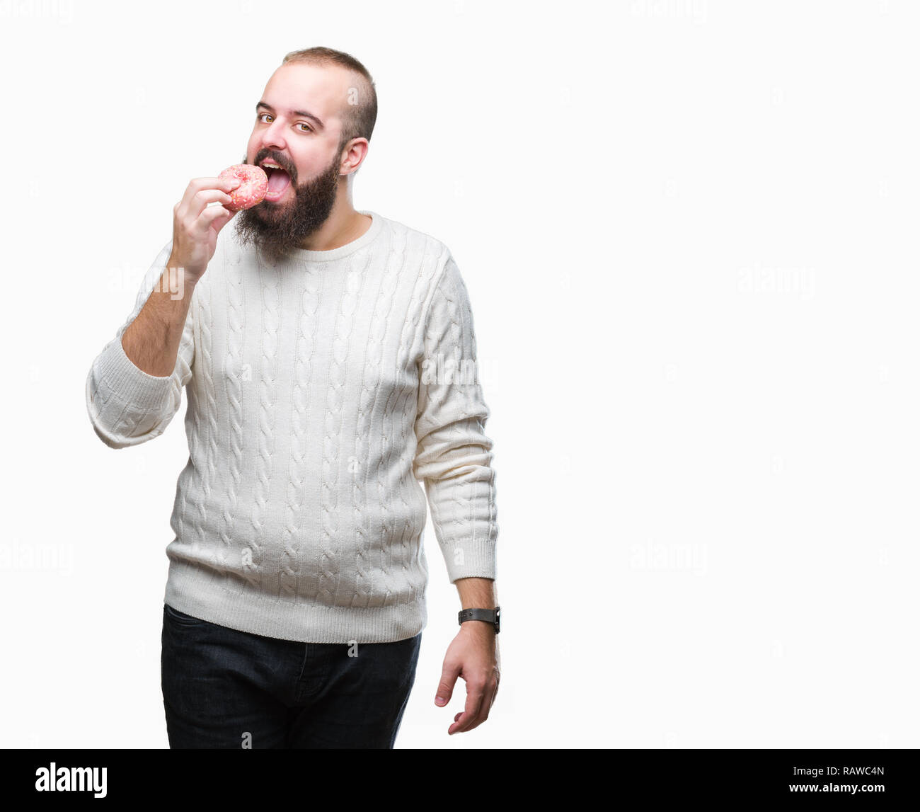 Young caucasian hipster man eating sweet donut over isolated background ...