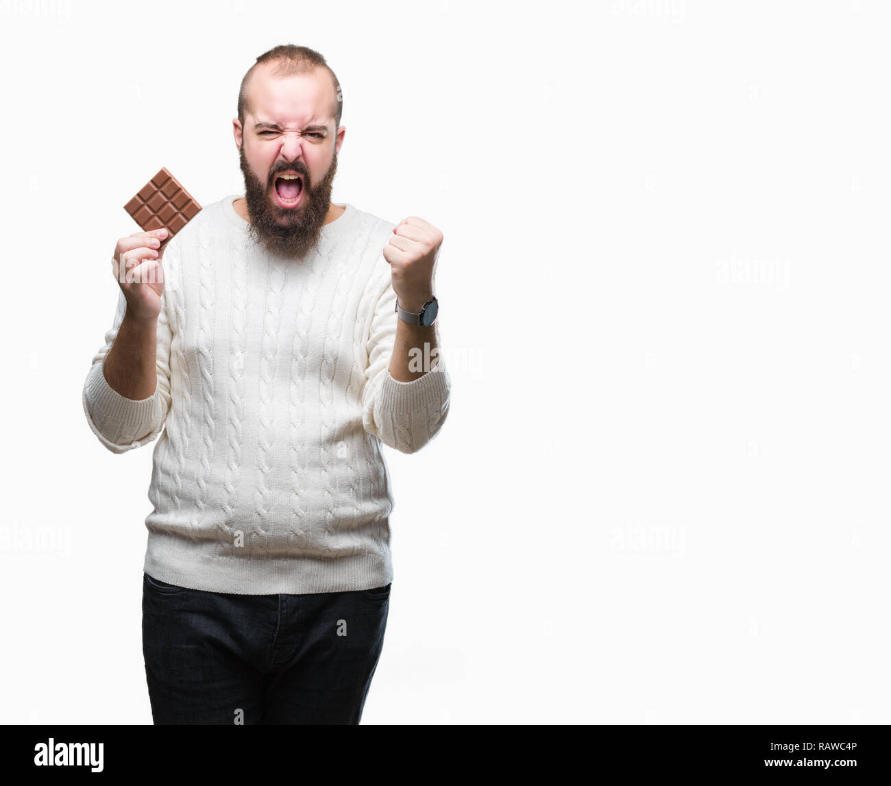 Young hipster man eating chocolate bar over isolated background annoyed ...