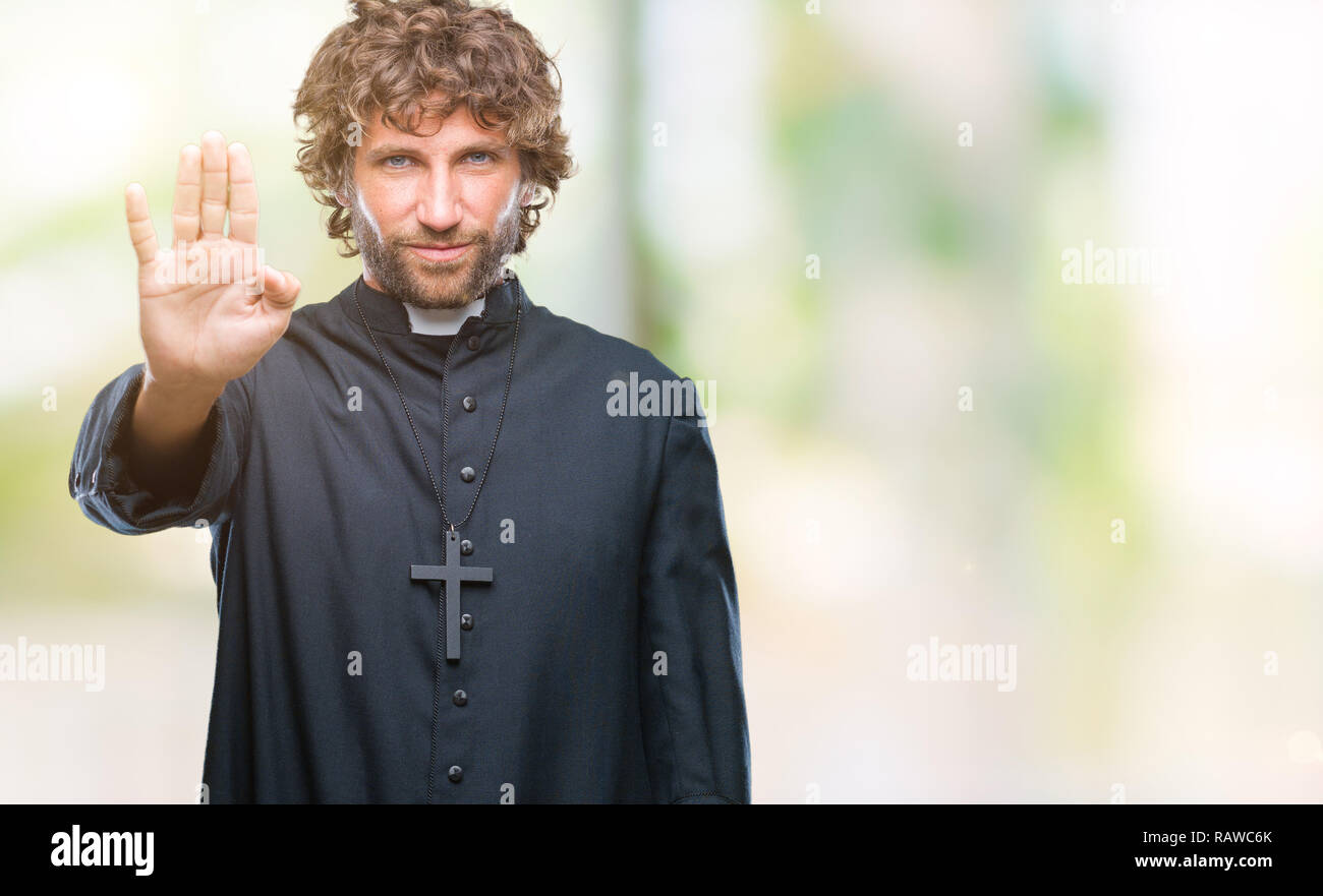 Handsome hispanic catholic priest man over isolated background doing ...