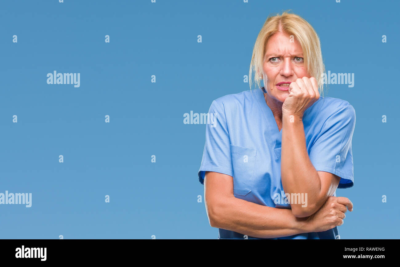 Middle age blonde woman wearing doctor nurse uniform over isolated ...