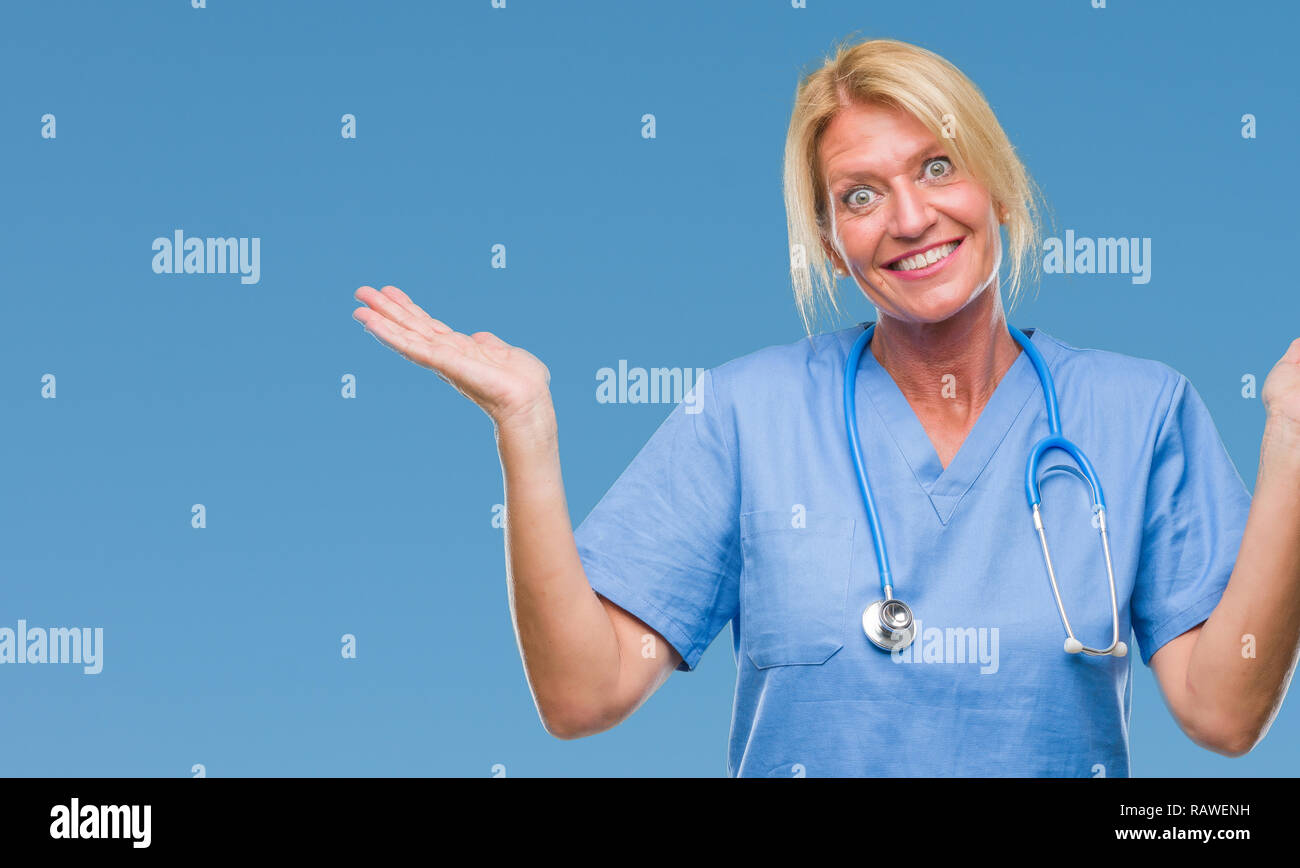 Middle age blonde nurse surgeon doctor woman over isolated background ...